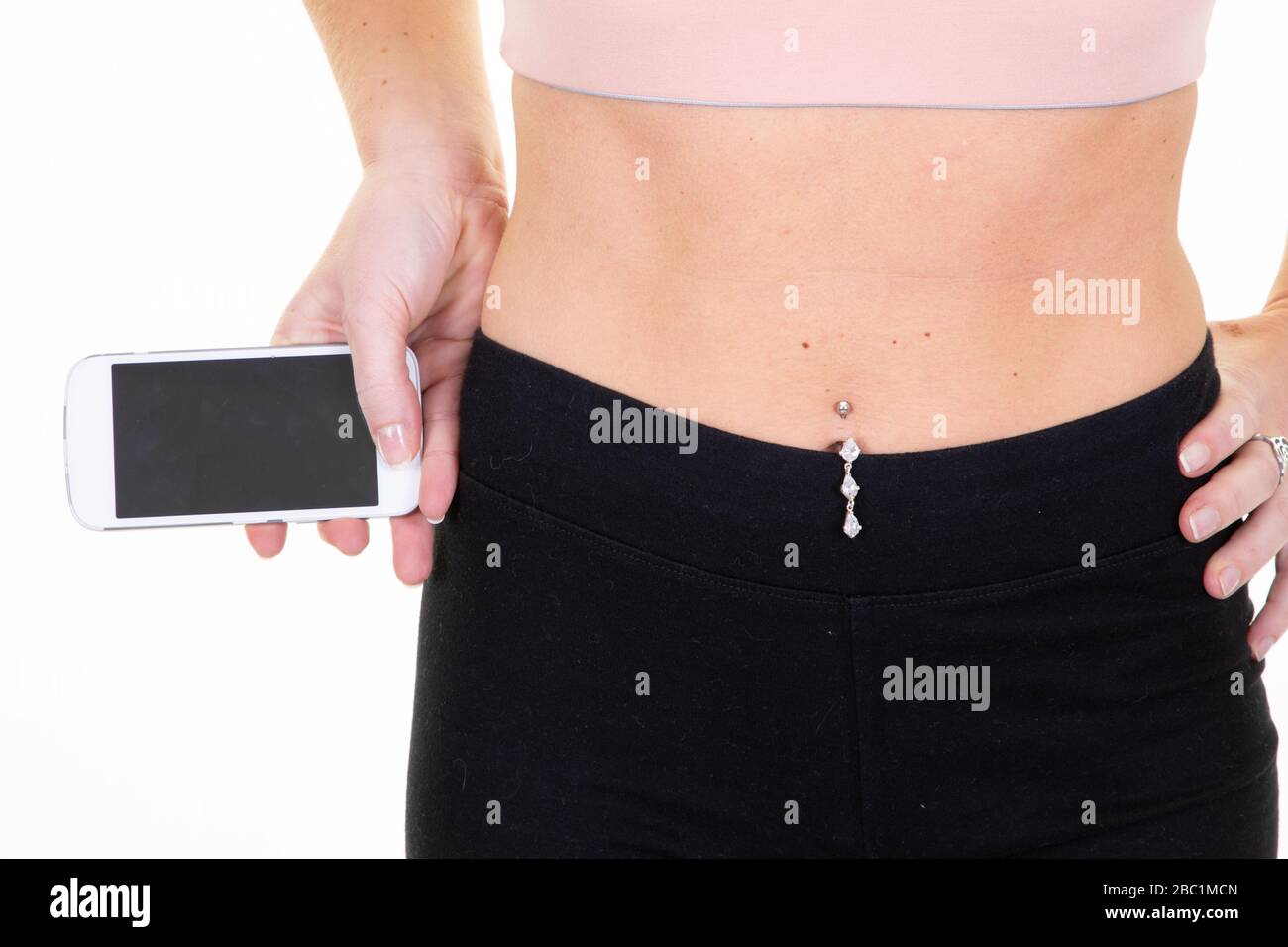 belly woman slim sporty holding smartphone with copy space on blank ...