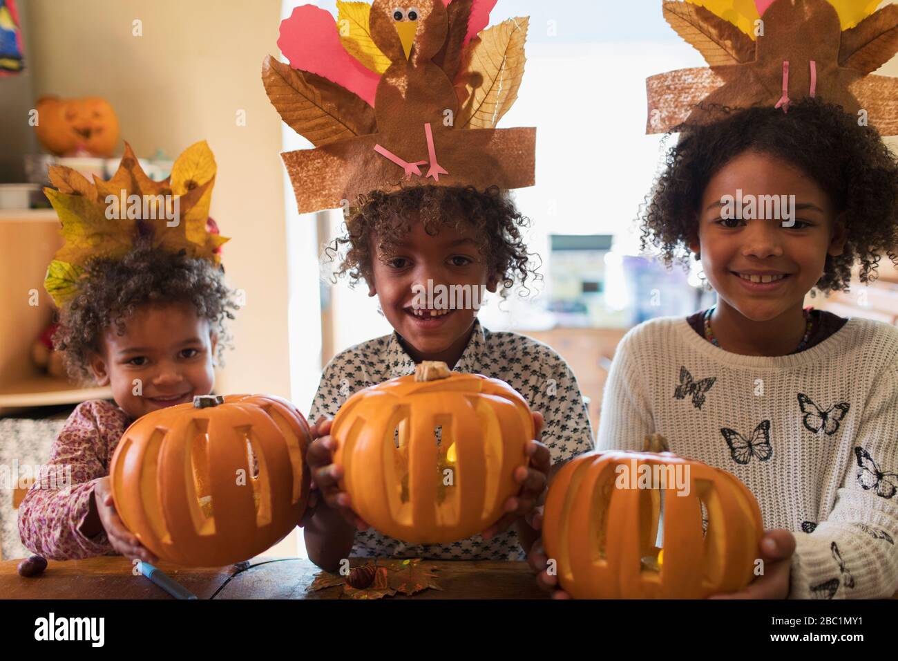 Portrait happy brother and sisters with turkey hats and pumpkins Stock ...