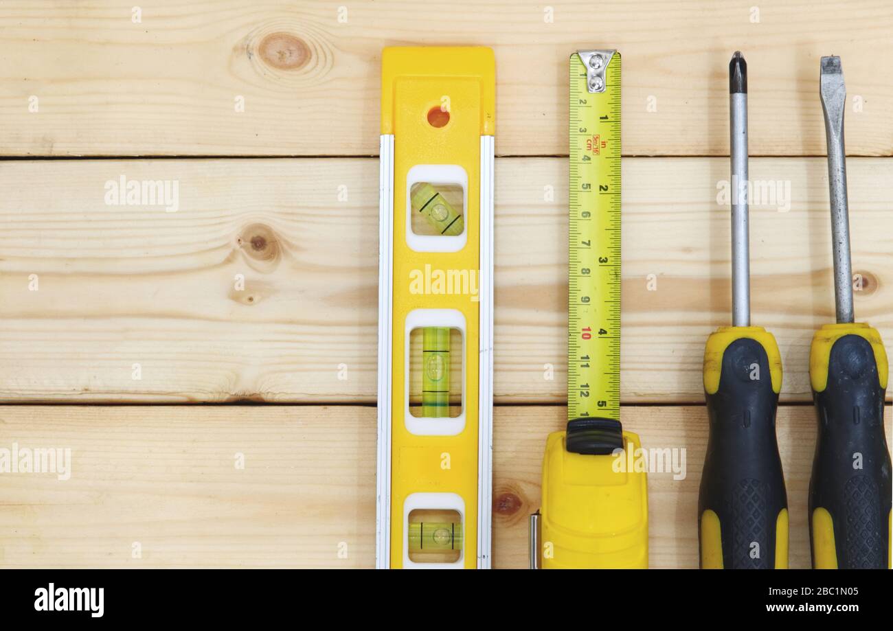 Tools set on wood table. screwdriver, tape measure and leveling ...