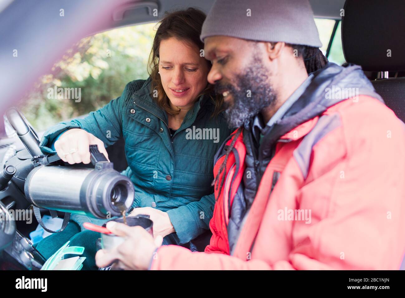 Couple drinking coffee inside car Stock Photo - Alamy