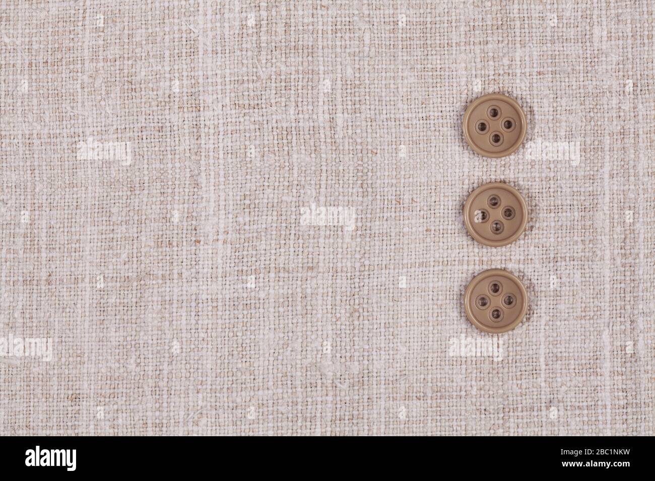 three buttons in a row on fabric textile background Stock Photo - Alamy
