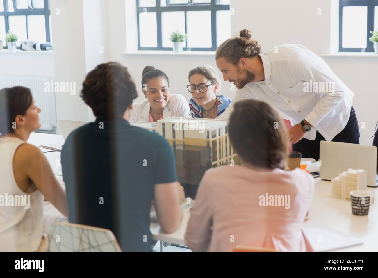 Architects examining model in conference room meeting Stock Photo - Alamy