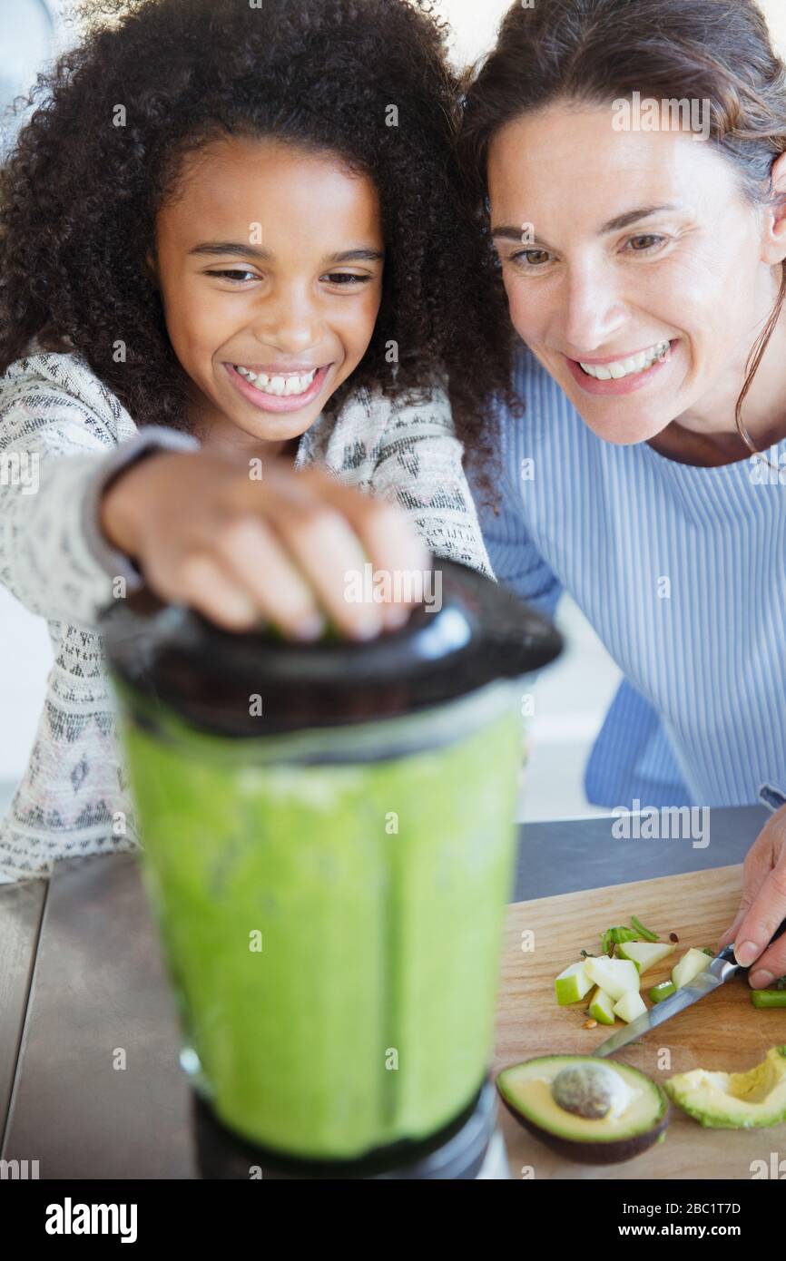 Mother and daughter making healthy green smoothie in blender Stock ...