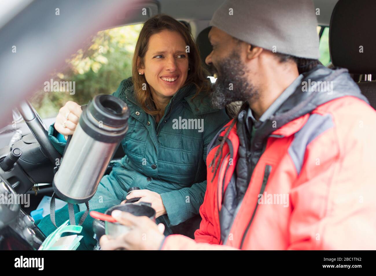 Happy couple drinking coffee in car Stock Photo - Alamy