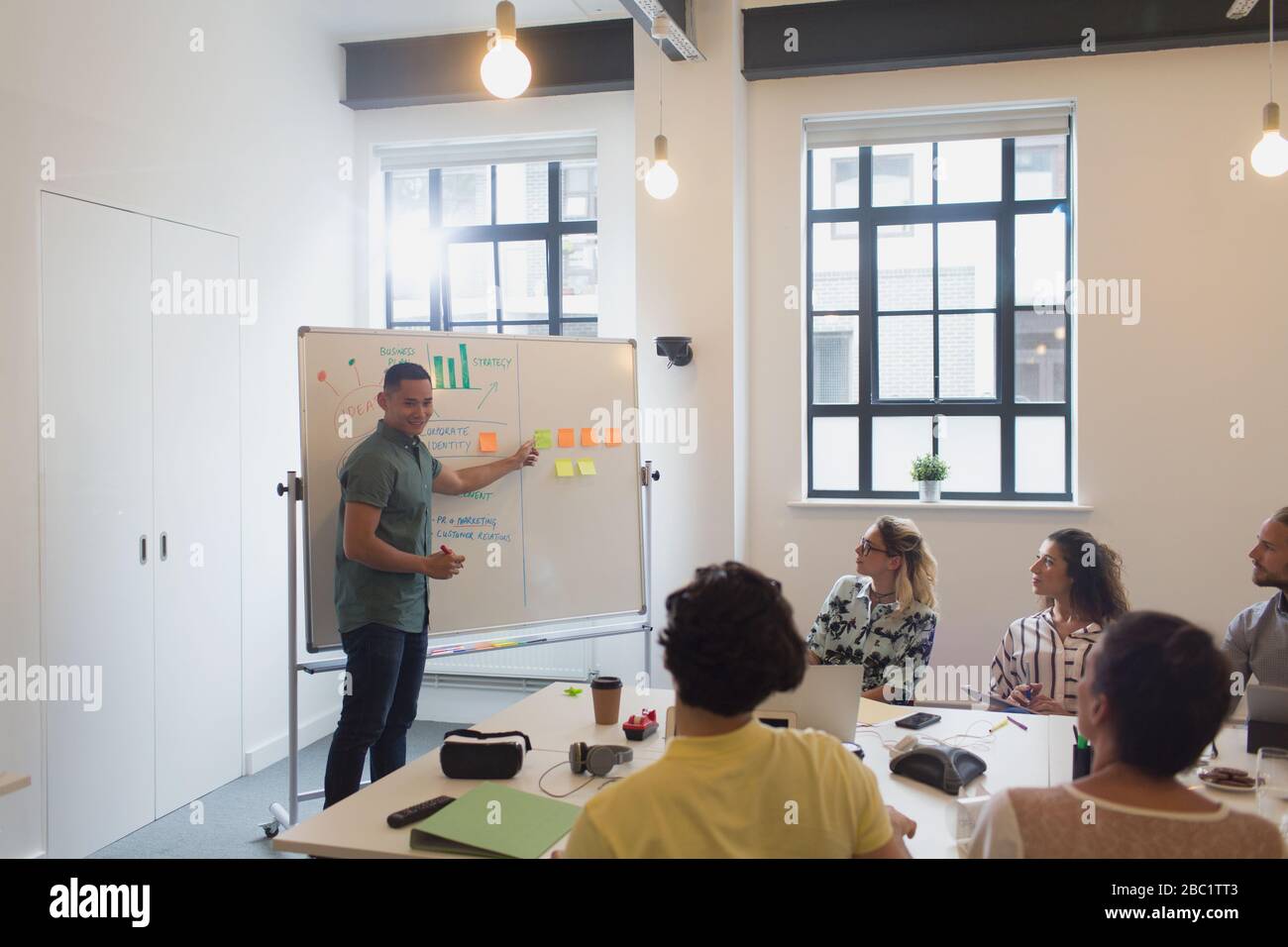 Male designer at whiteboard leading conference room meeting Stock Photo ...