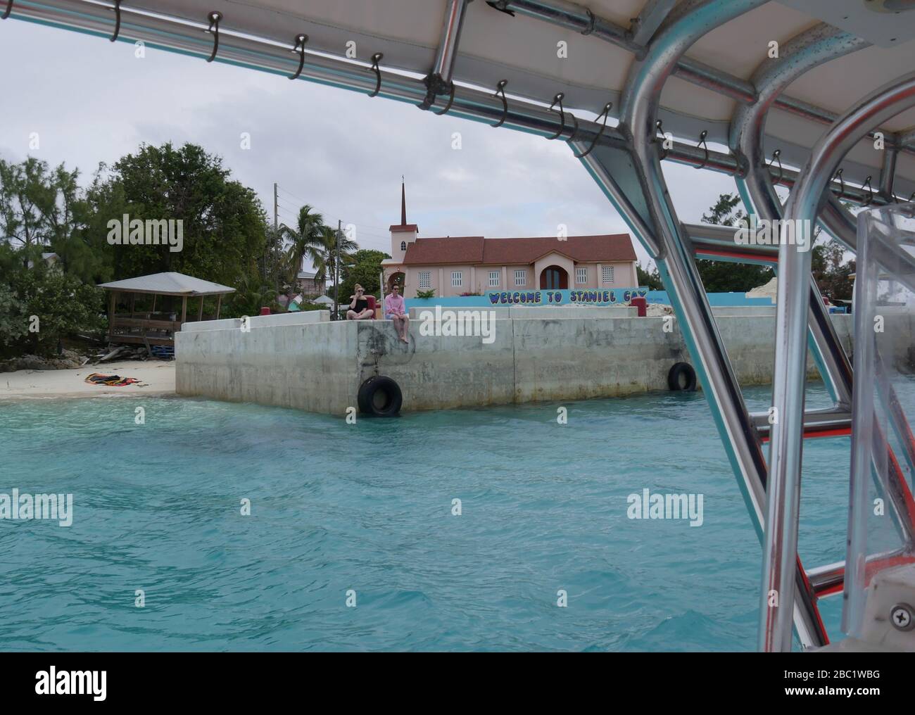 Staniel Cay, Exuma Cays- January 2018: A couple sits on the dock of ...