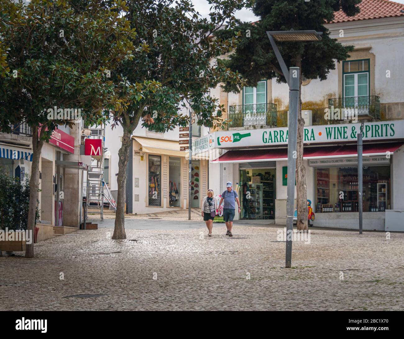 A middle aged couple holding hands, walking through the main square in ...