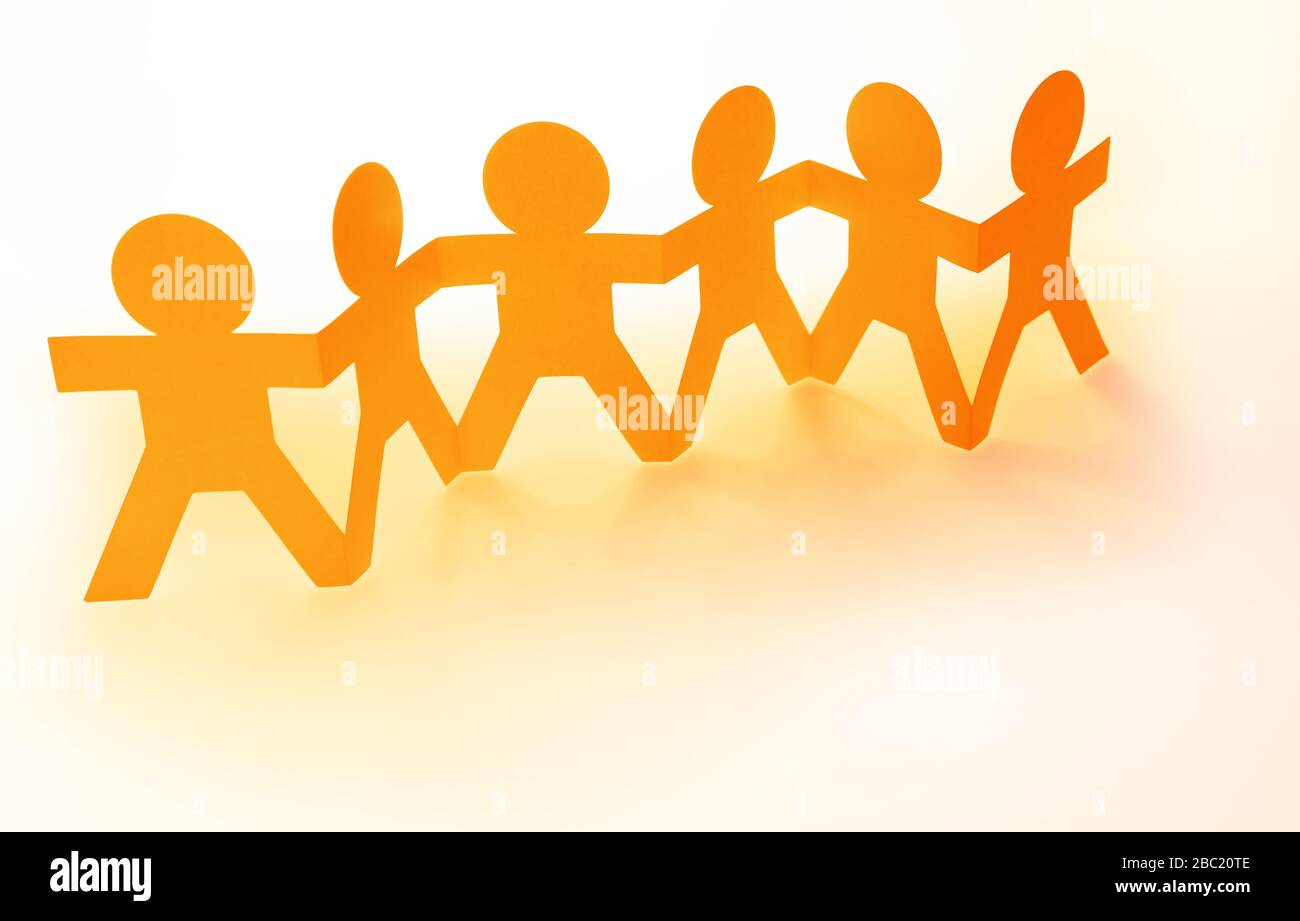 Paper chain team holding hands. Teamwork. Partnership Stock Photo - Alamy