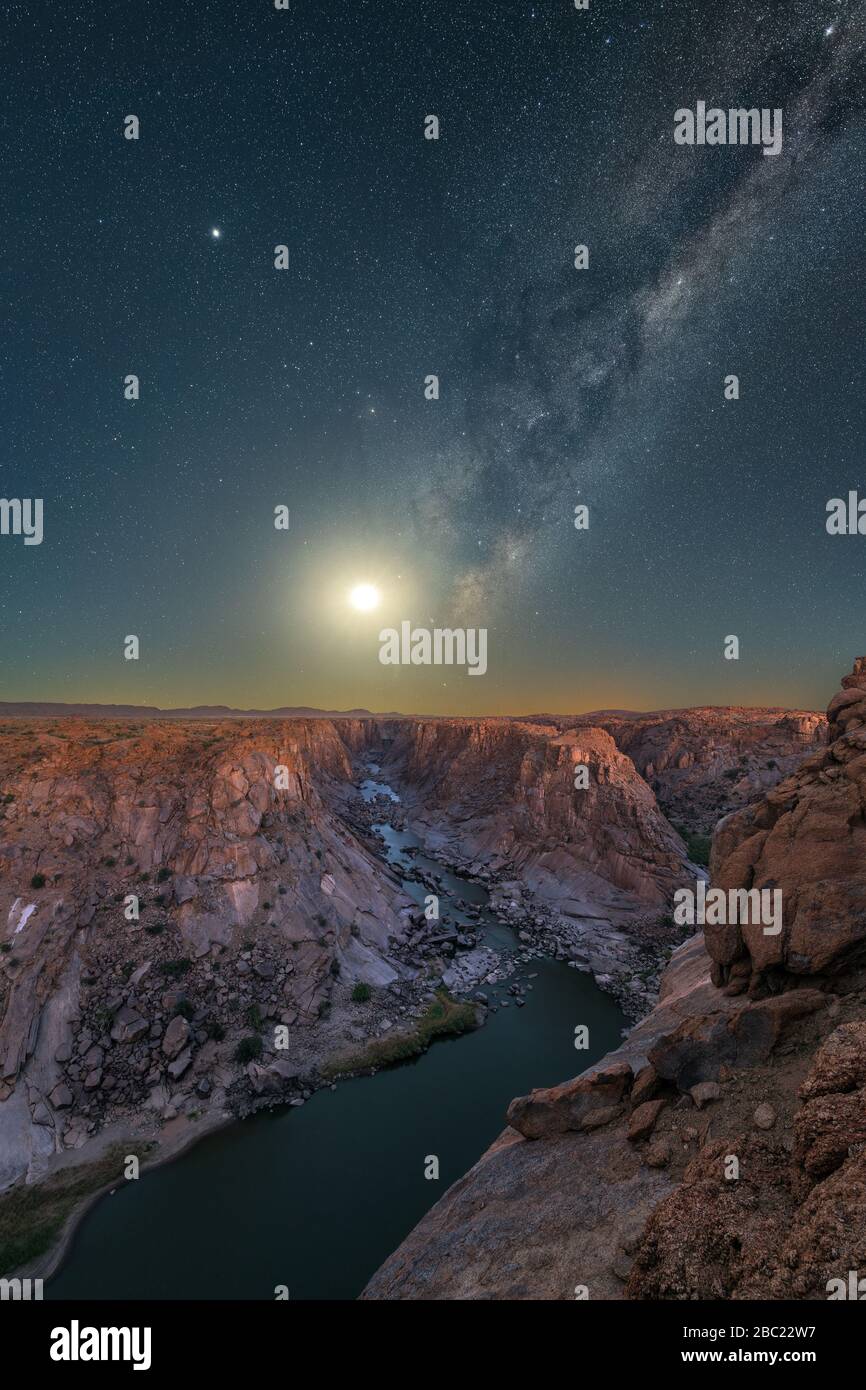 A majestic vertical night sky photograph with the Moon rising below the ...