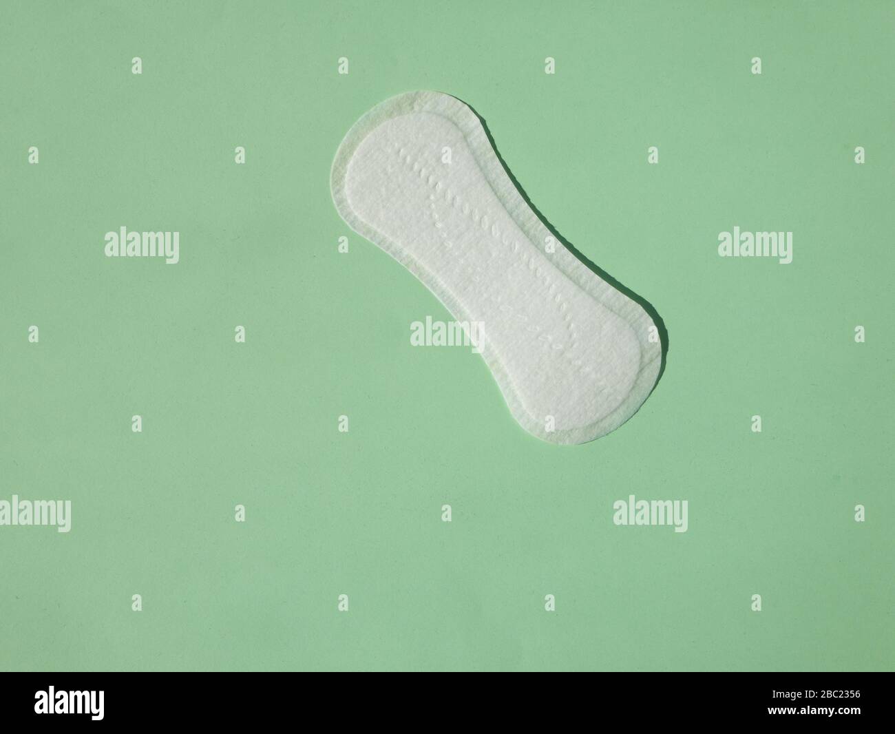Close up view of woman's sanitary pad on color back. Top view. Copy ...
