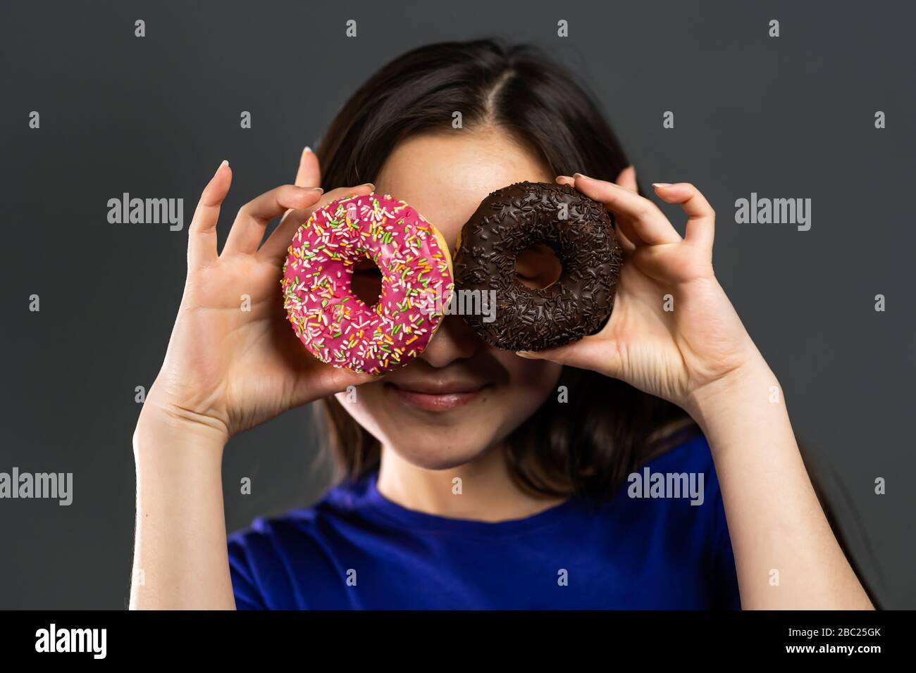 Portrait of cheerful beautiful asian woman dancing with sweets colorful ...