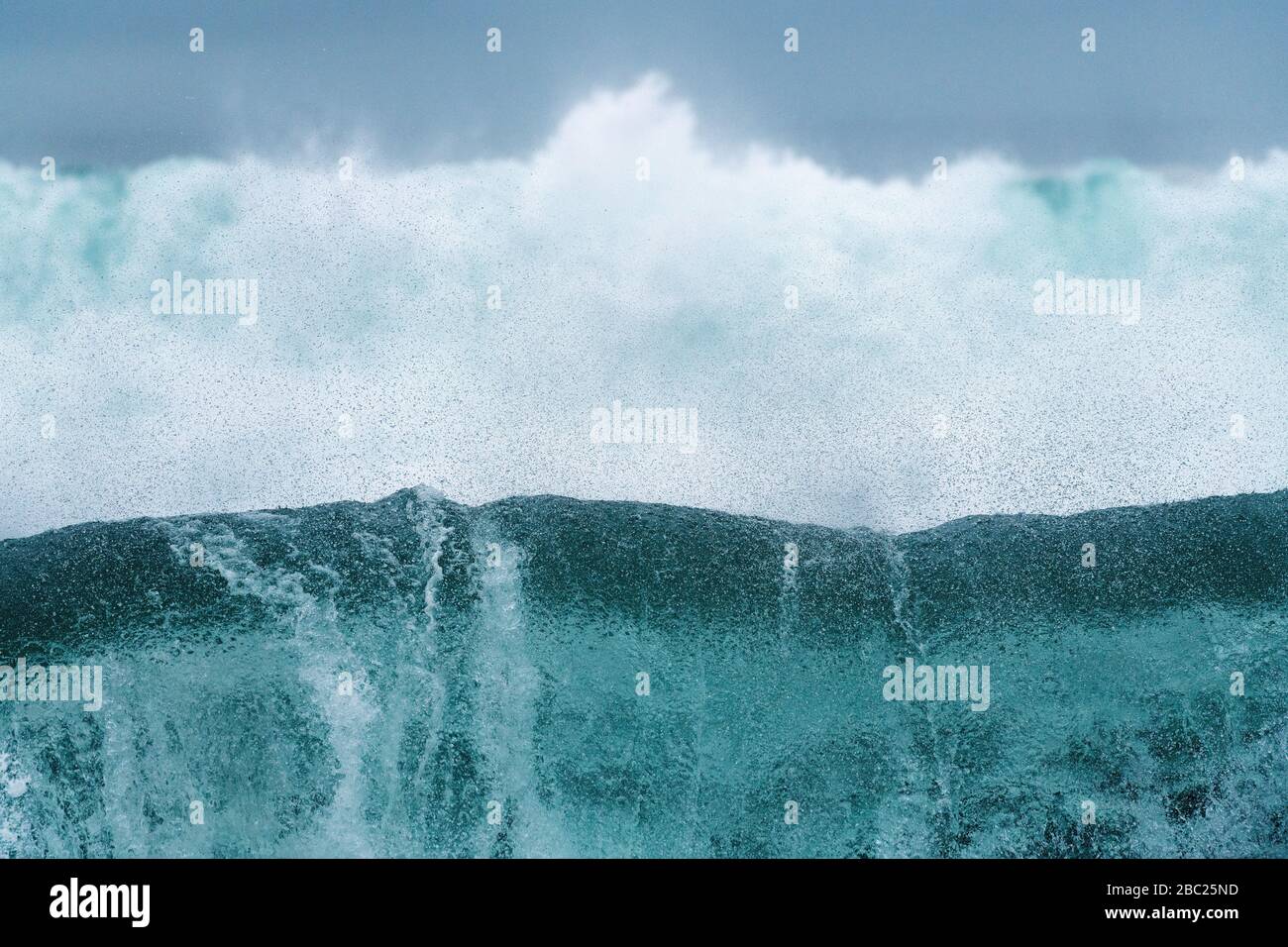 A dramatic close up seascape photograph of a crashing tubular wave ...