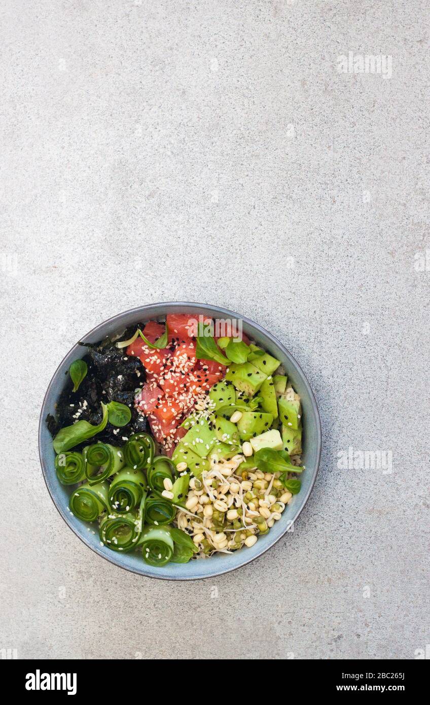 Poke bowl with rice, avocado, pickled cucumber and crispy sea kale ...