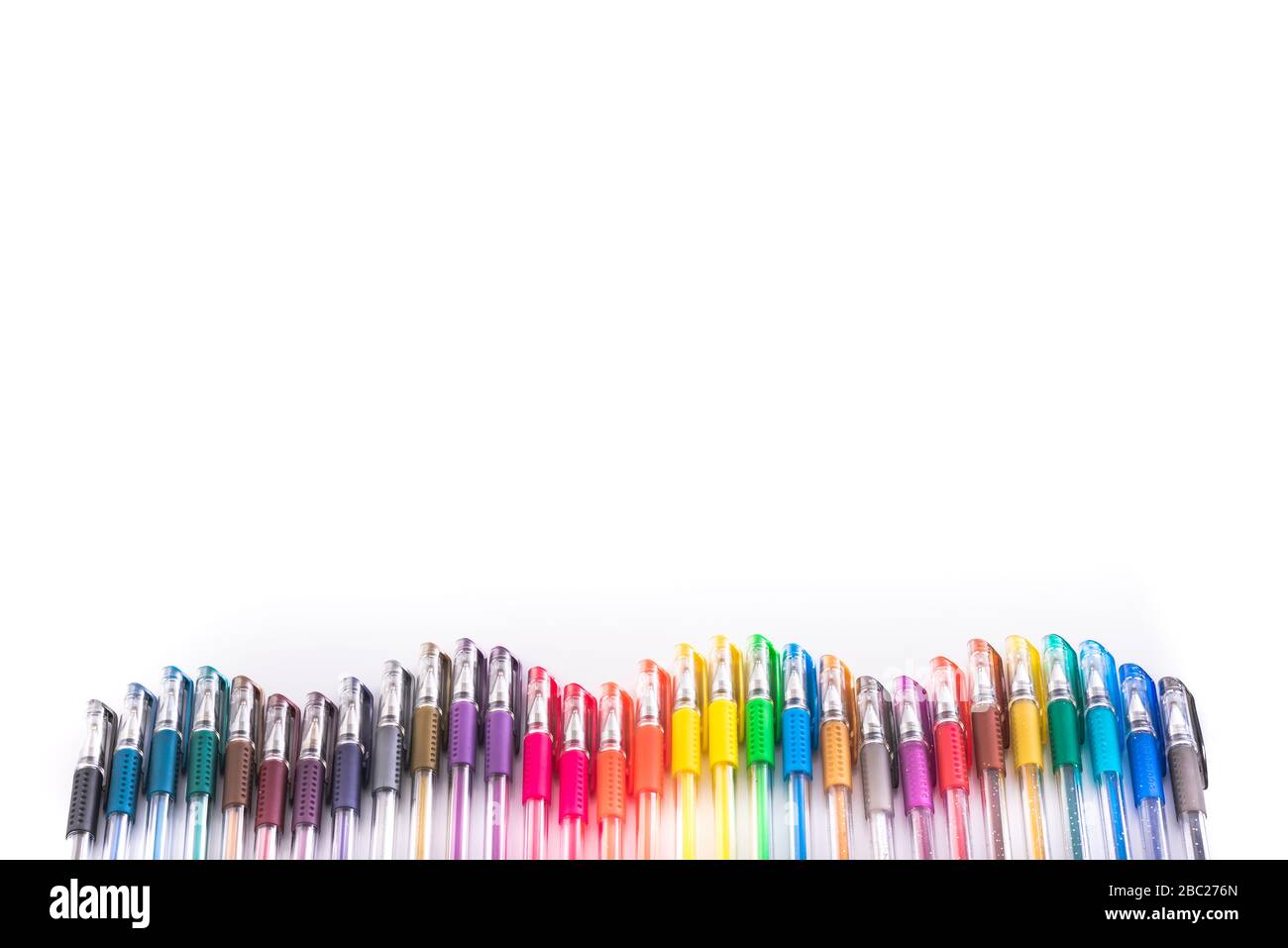 Group of colorful pens for drawing, arranged in a waveform on a table ...