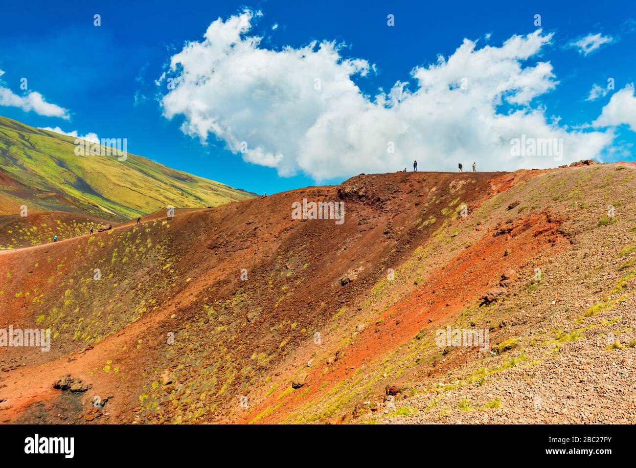 Beautiful colorful lava hills with group of people hiking to a volcanic ...