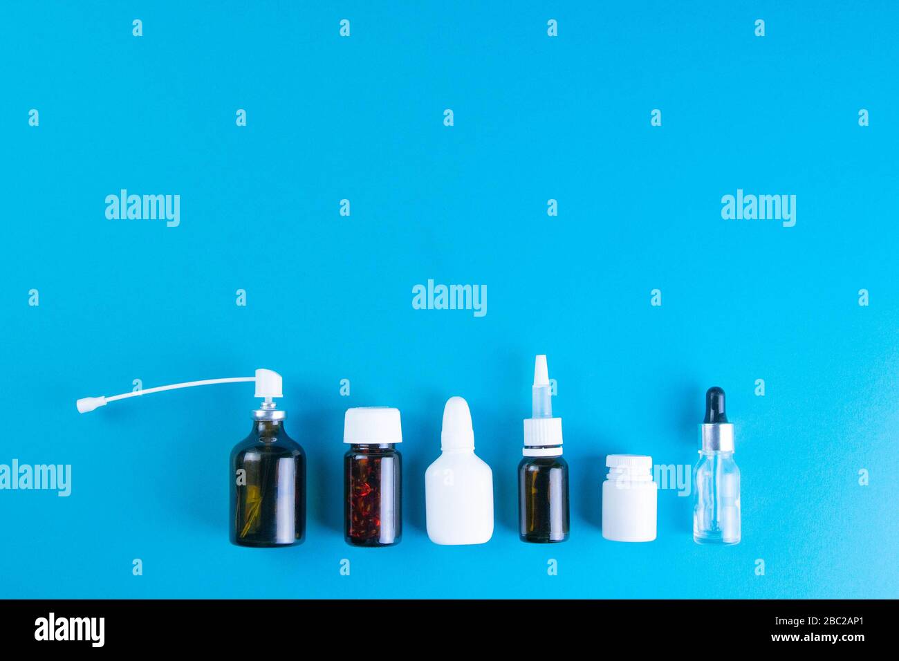 Different vials with and sprays with medicines are lined in a straight ...