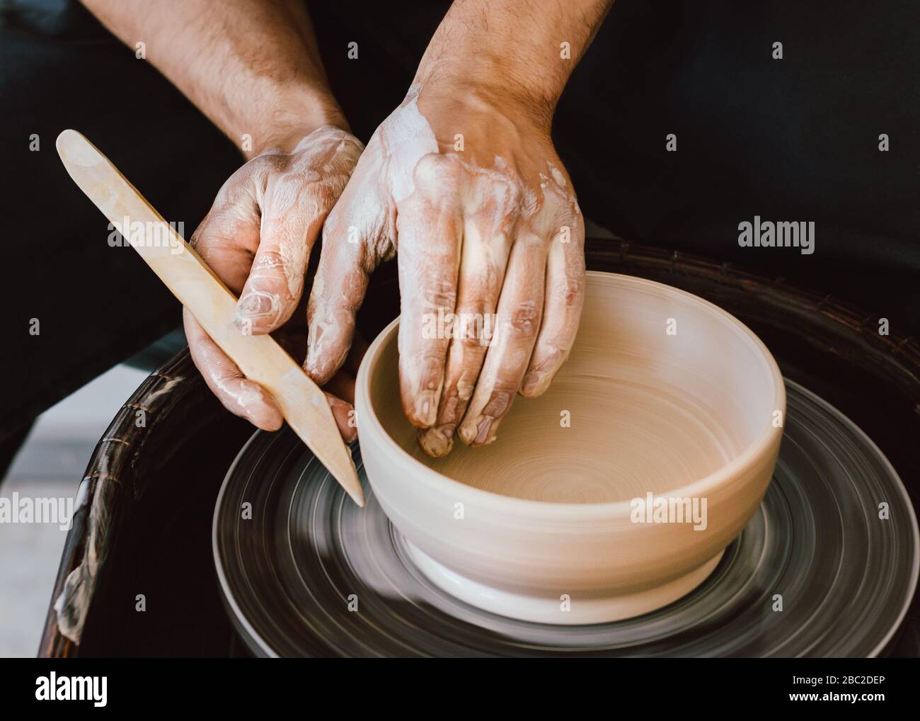 Ceramist at a pottery workshop Ceramist is bringing finishing touches ...
