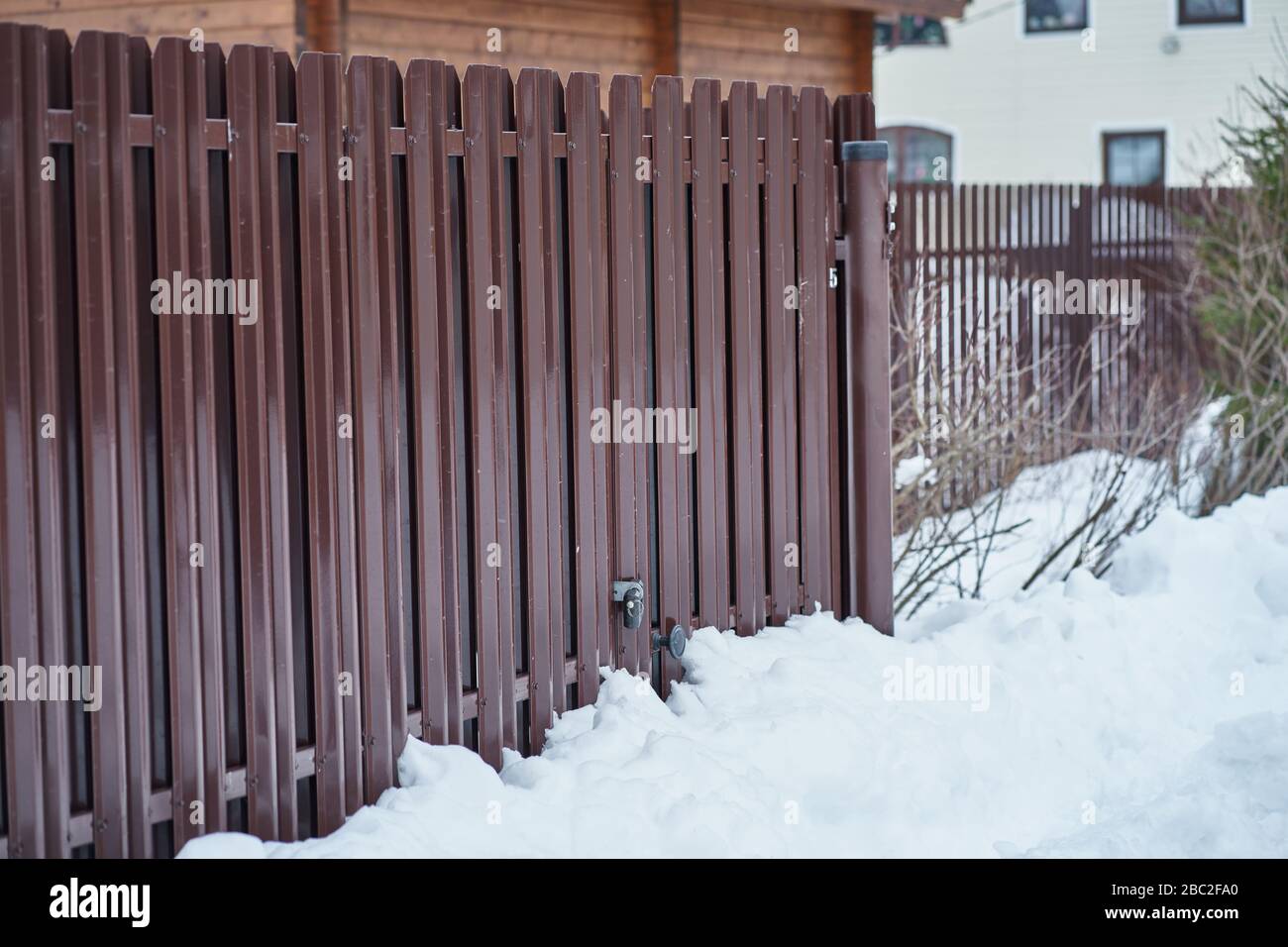 Metal Fence and snow in countryside, gate with padlock, side view Stock ...