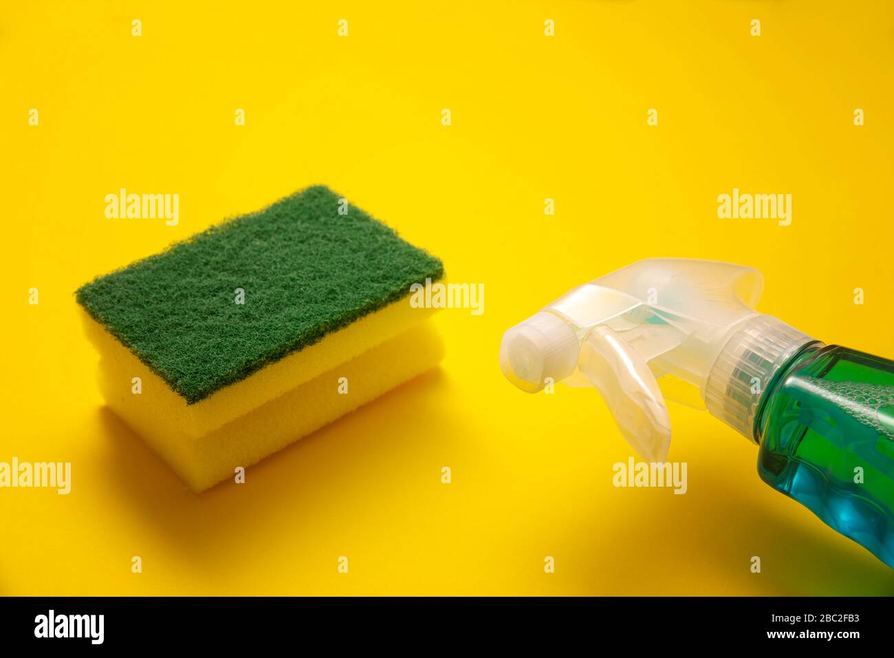 liquid detergent in sparay bottle and sponge on yellow background Stock ...
