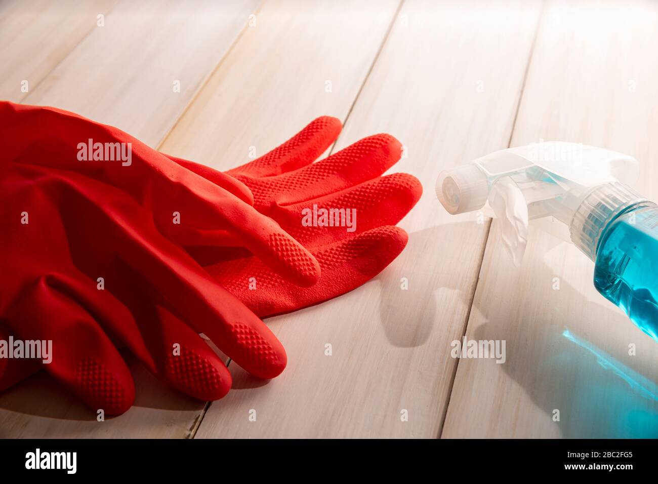 red rubber gloves and liquid detergent in sparay bottle on wooden ...