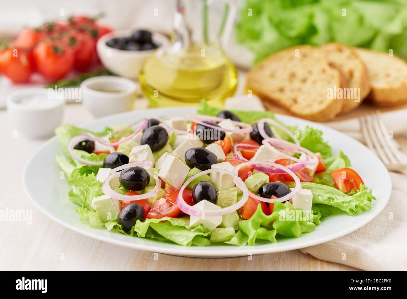 Greek salad on white plate on old rustic white wooden table, fresh ...