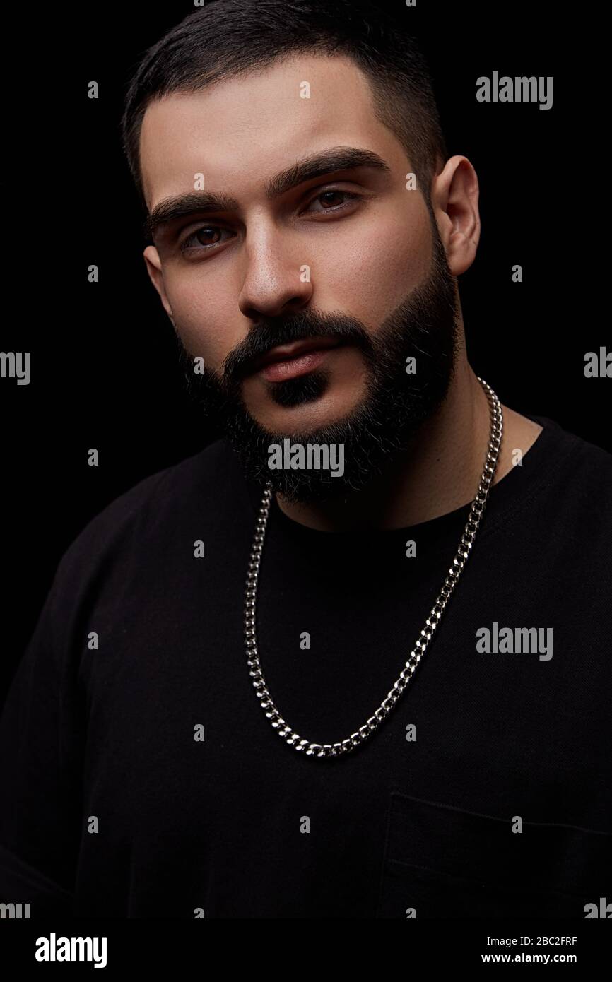 close-up of a dramatic portrait of a young serious guy, musician ...
