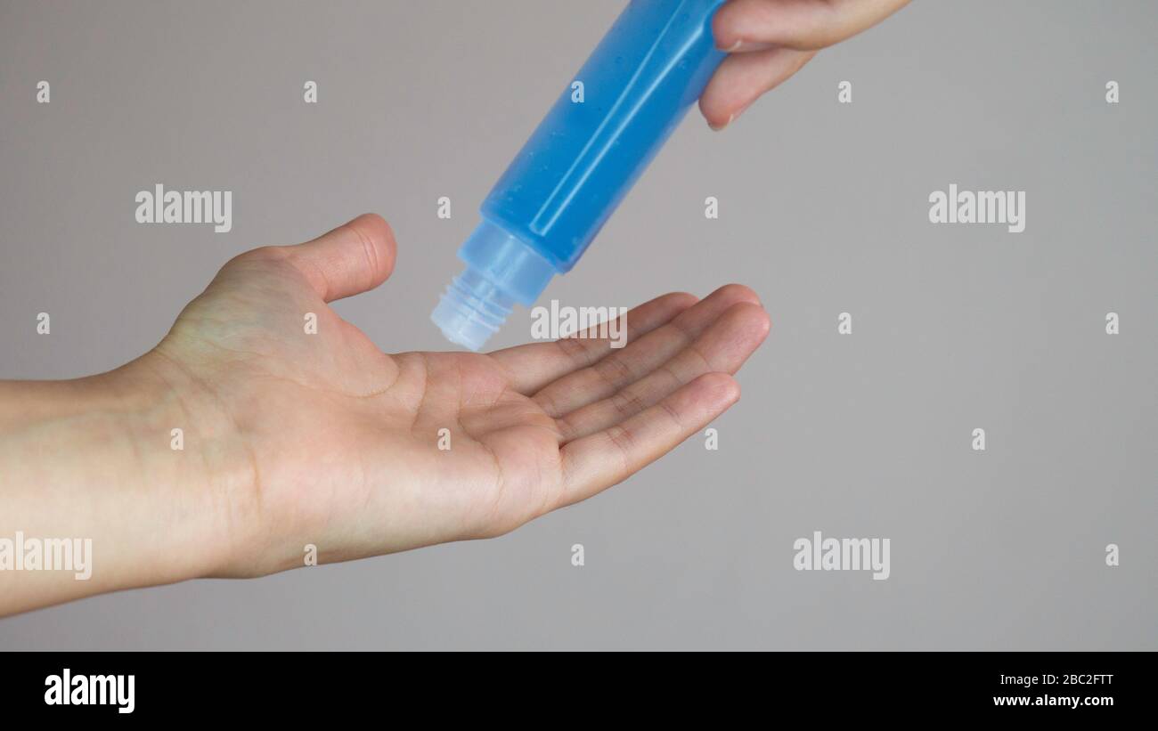 Hand of lady that applying alcohol gel to prevent spread of germs ...