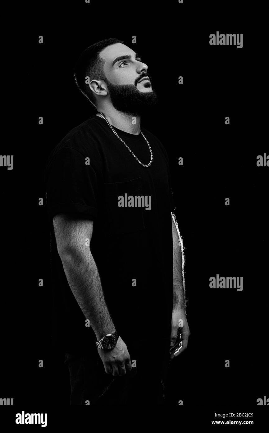 a dramatic portrait of a young serious guy, musician, singer, rapper ...