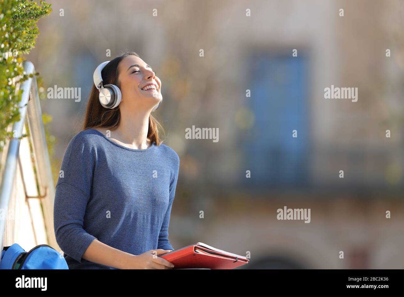 Happy student meditating listening to music wearing headphones sitting ...