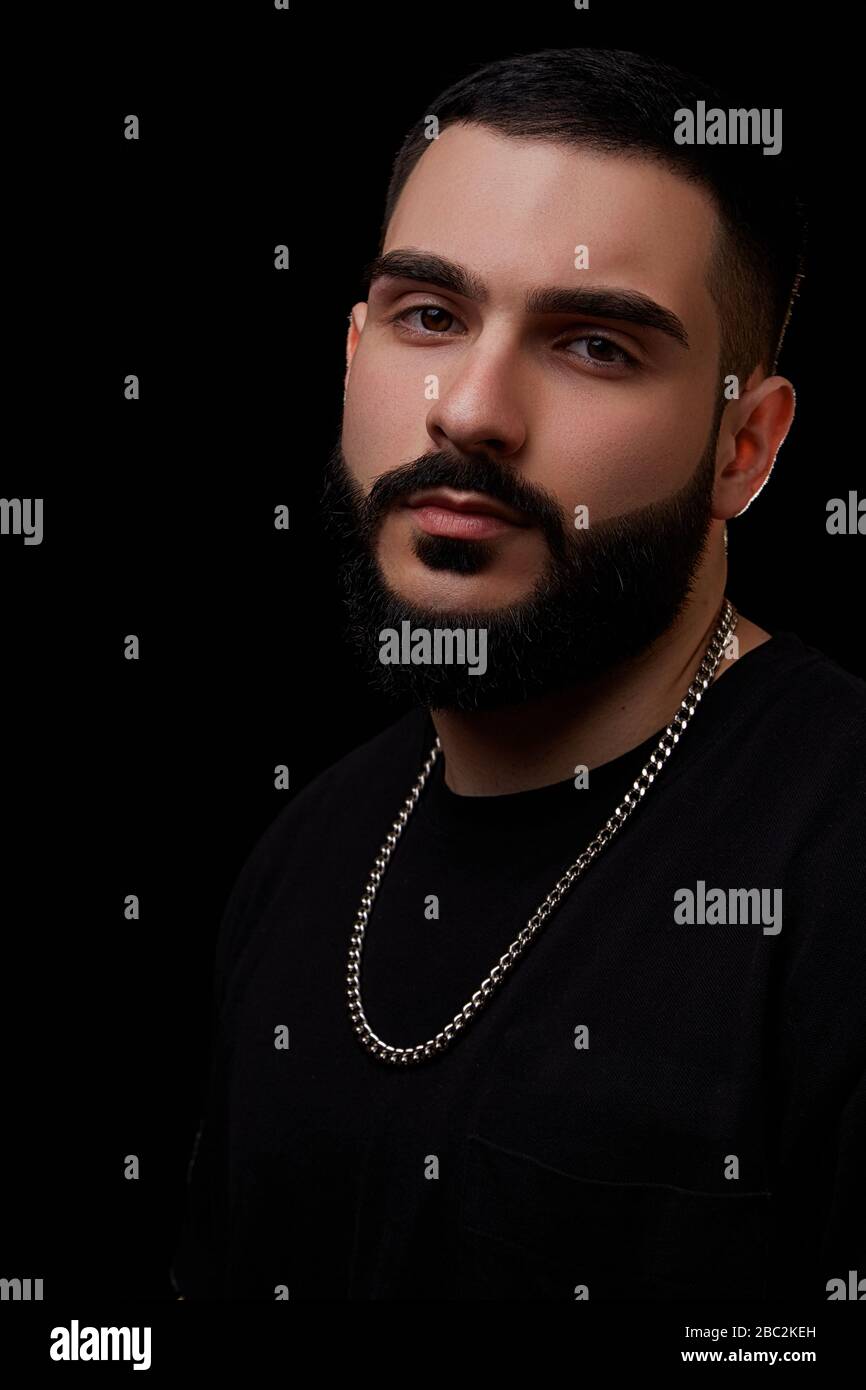 close-up of a dramatic portrait of a young serious guy, musician ...