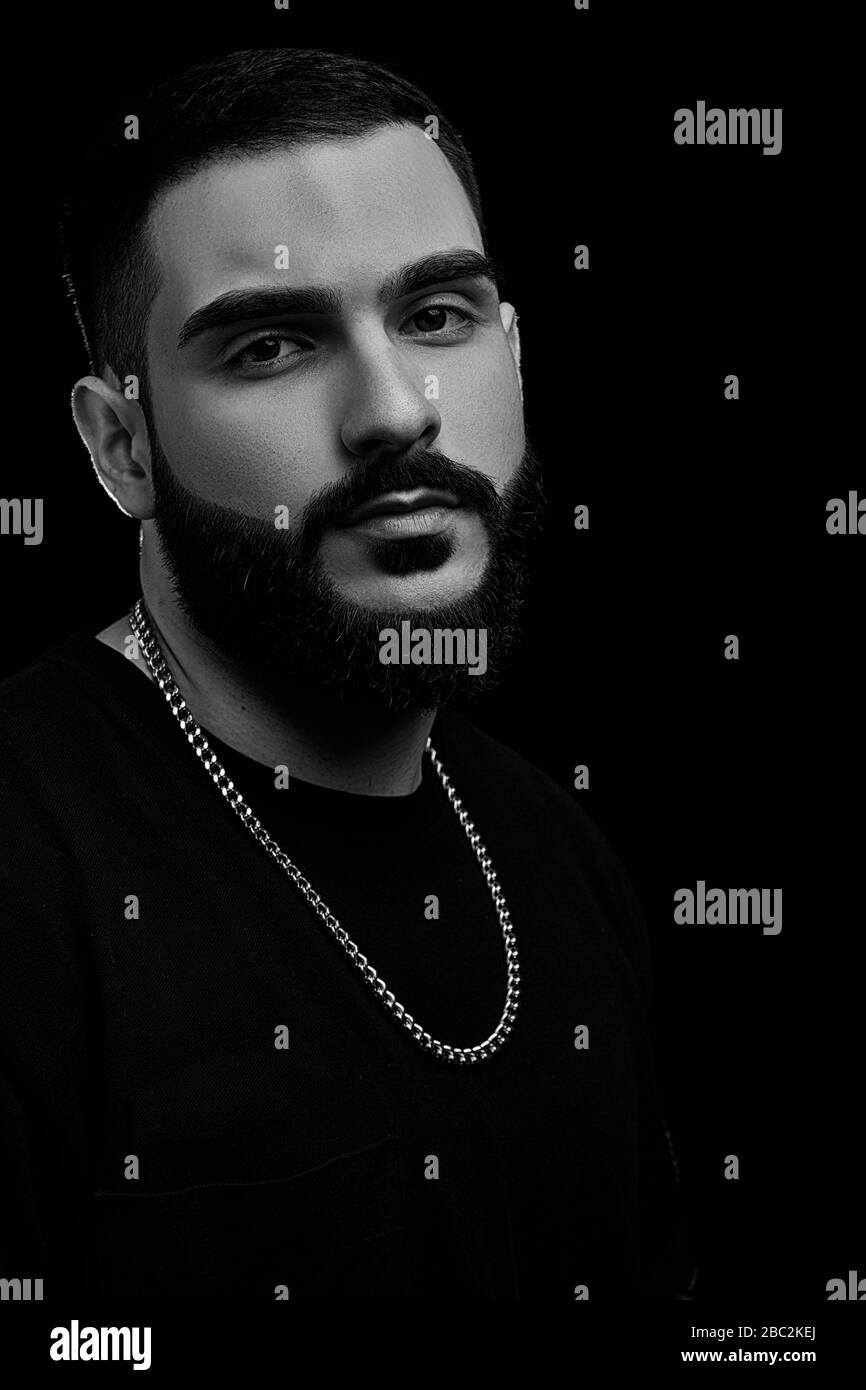 close-up of a dramatic portrait of a young serious guy, musician ...