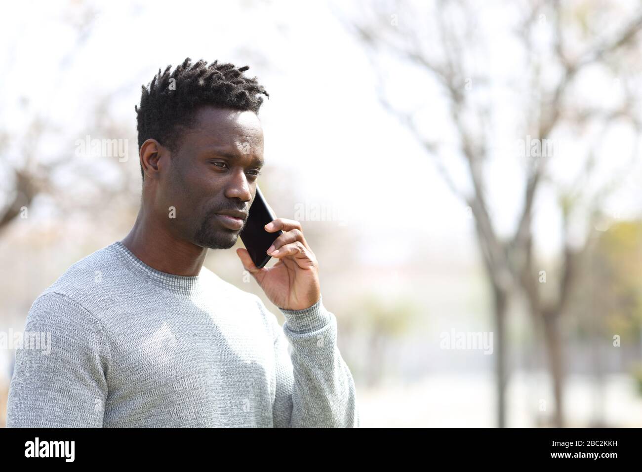 Serious guy calling phone park hi-res stock photography and images - Alamy