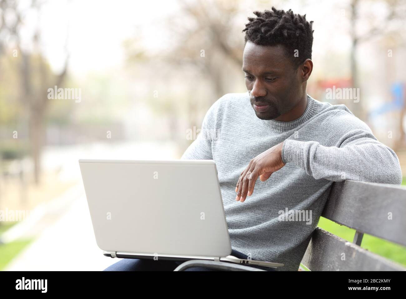 Man sitting on a park bench with a laptop hi-res stock photography and ...