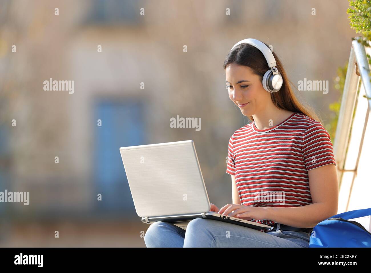 Student with laptop and headphones elearning sitting in a campus Stock ...