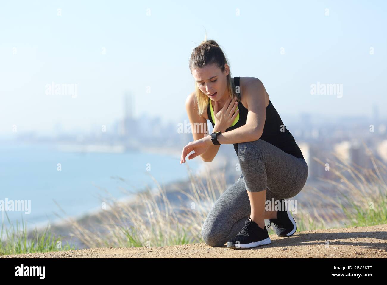 Tired stressed runner controlling pulsations checking smartwatch after ...