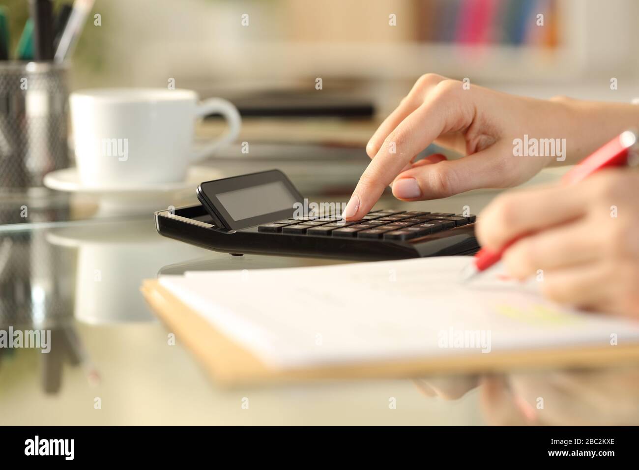 Close up of woman hands accounting with calculator taking notes sitting ...