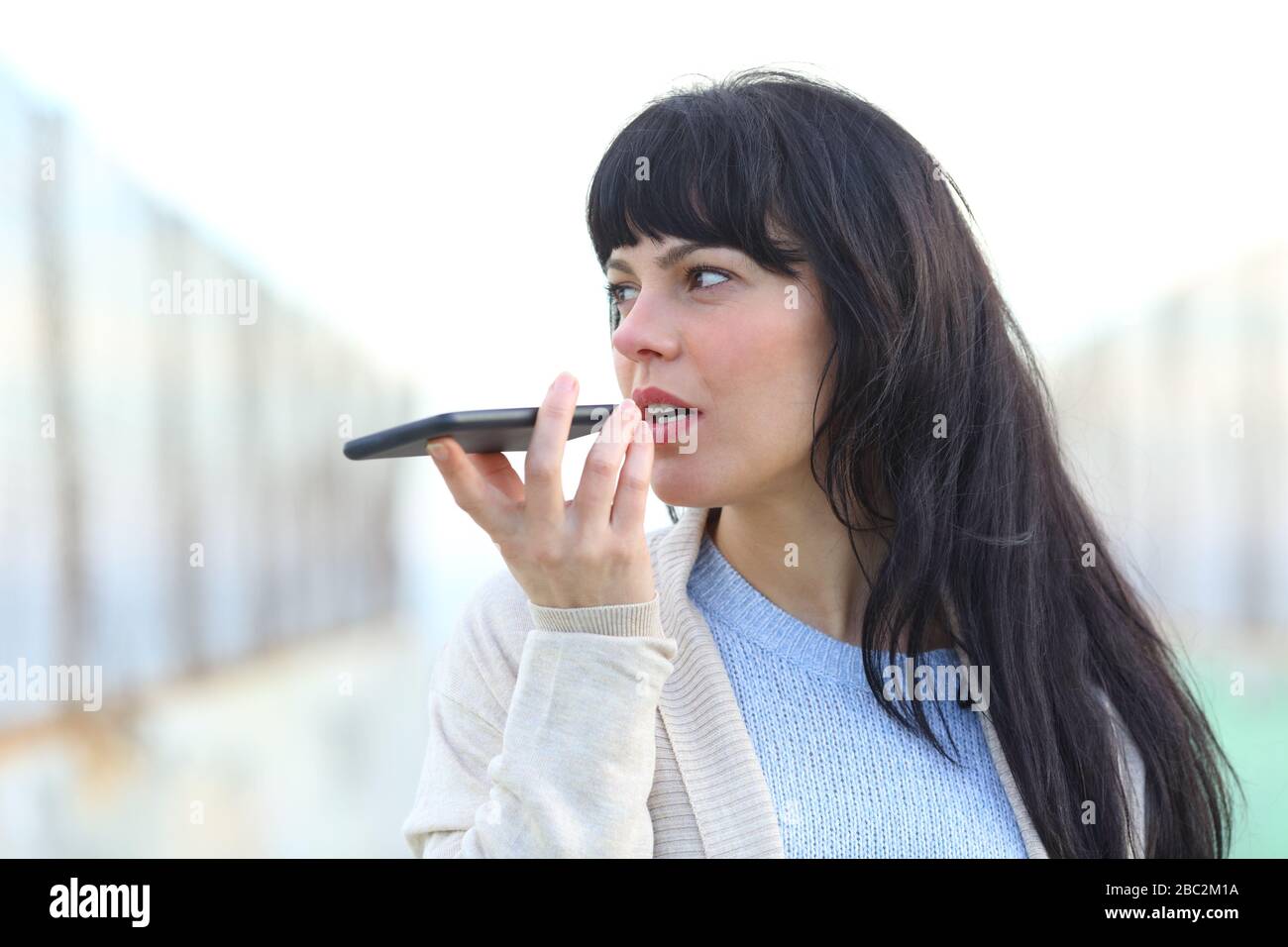 Adult woman recording audio using voice recognition on mobile phone in ...