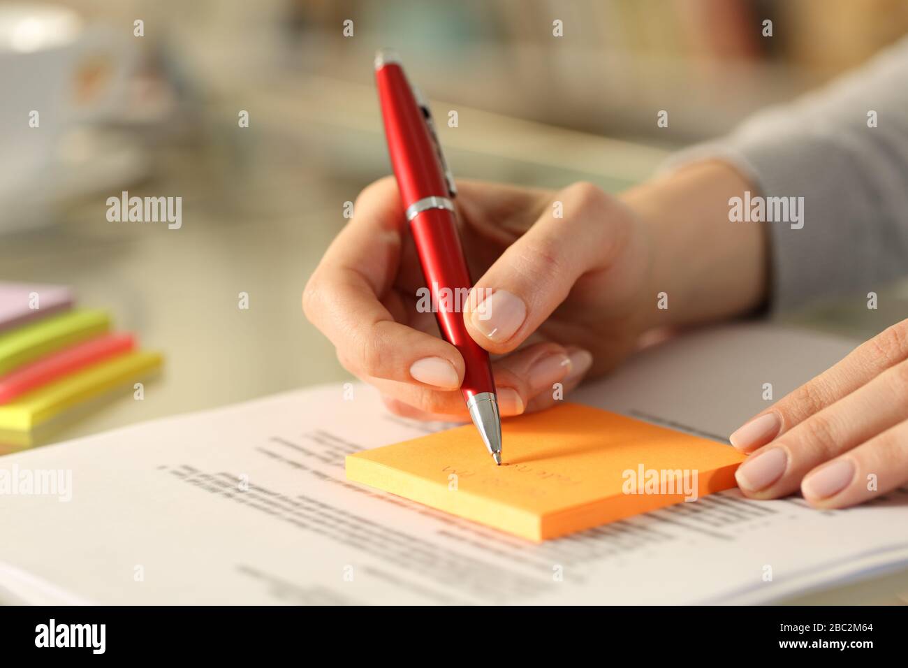 Close up of woman hands writing to do list with pen on sticky notes on ...