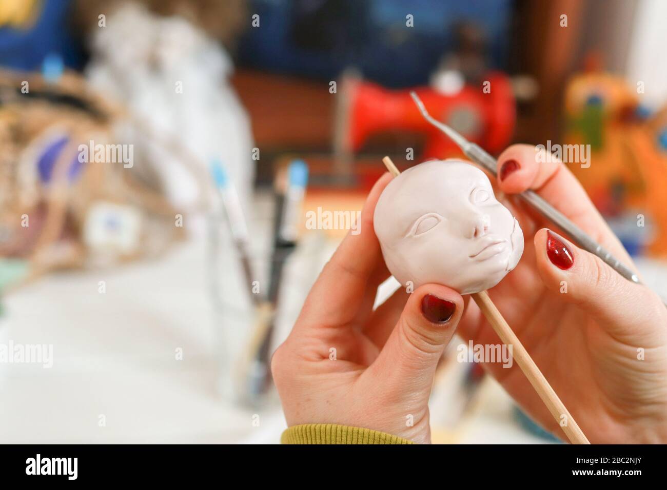 The artist making a new doll face at the toy factory. The master artist ...