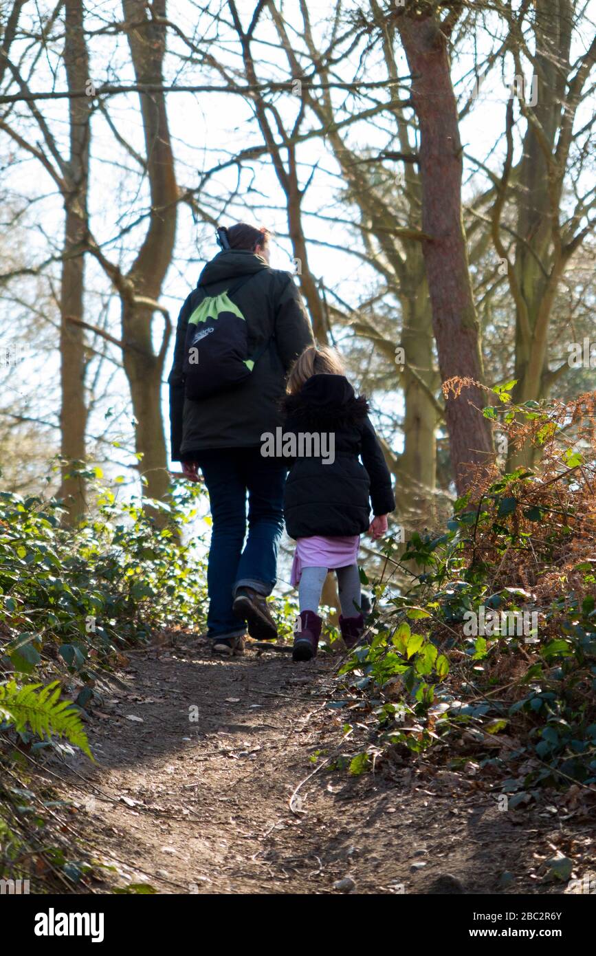 Mother & daughter / children kid daughters walking / walk along path ...