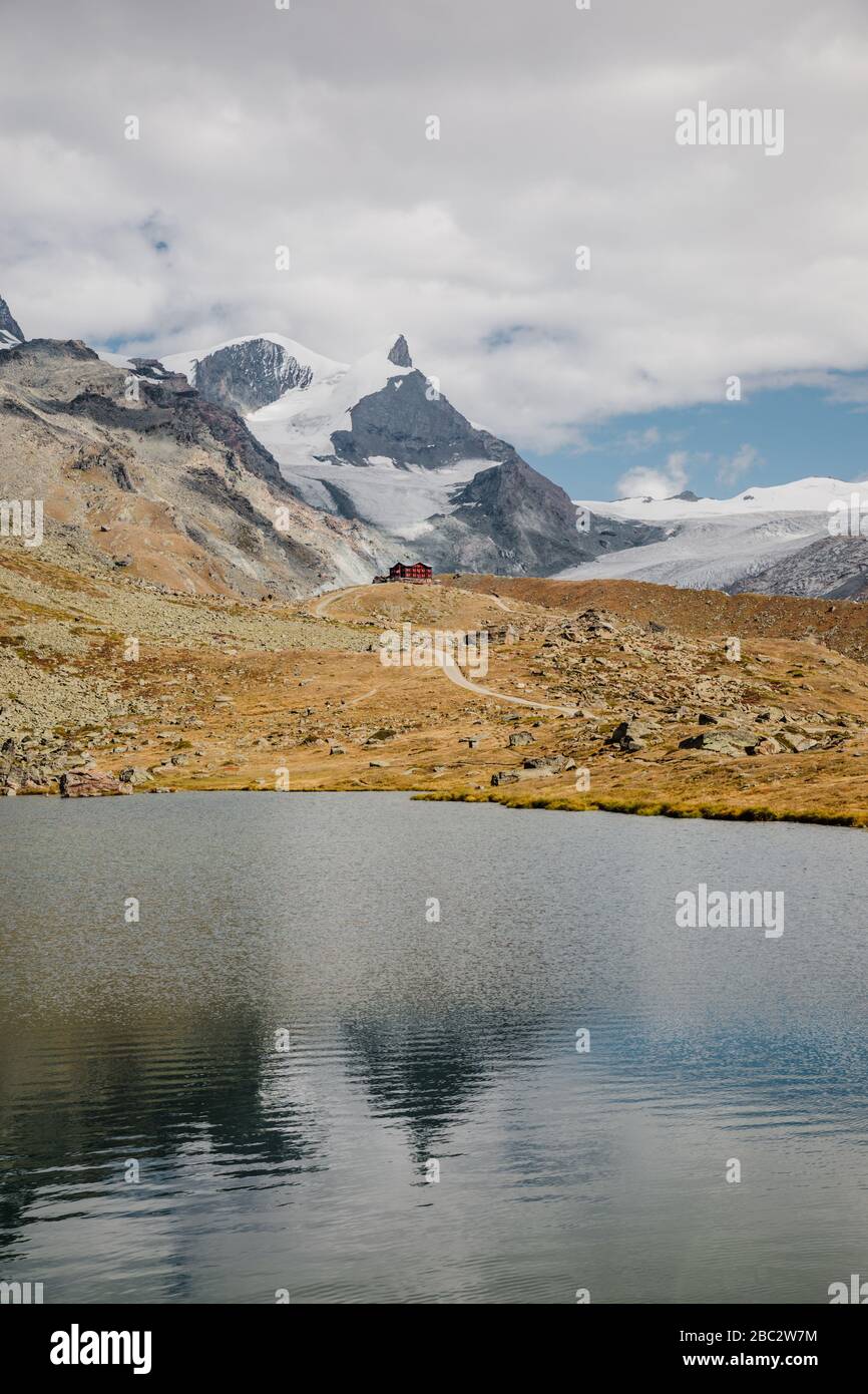 Small red tourists shelter house and beautiful mountains lake with ...