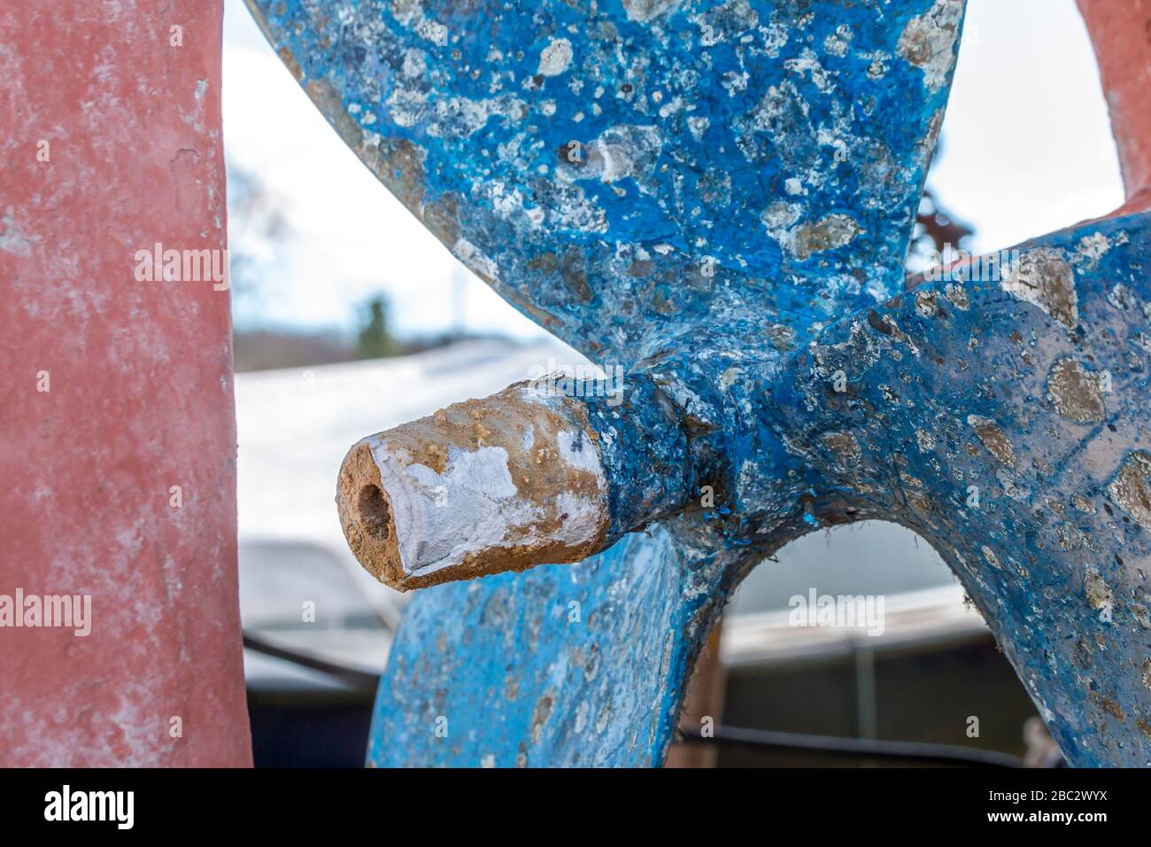 Old blue sailboat propeller in a red painted hull Stock Photo - Alamy