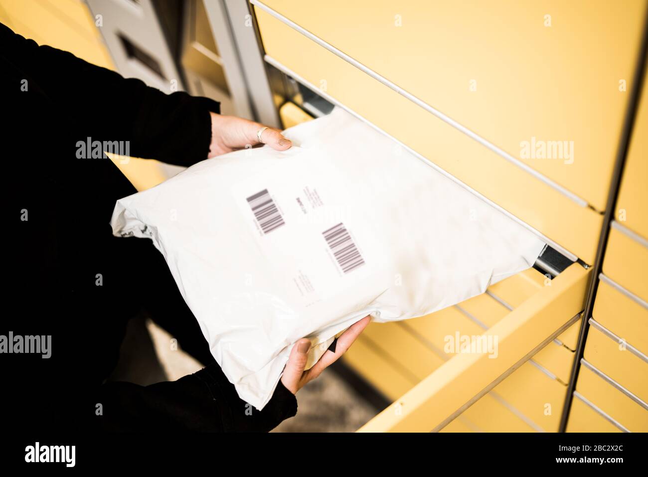 A woman picks up a package at a packing station Stock Photo - Alamy