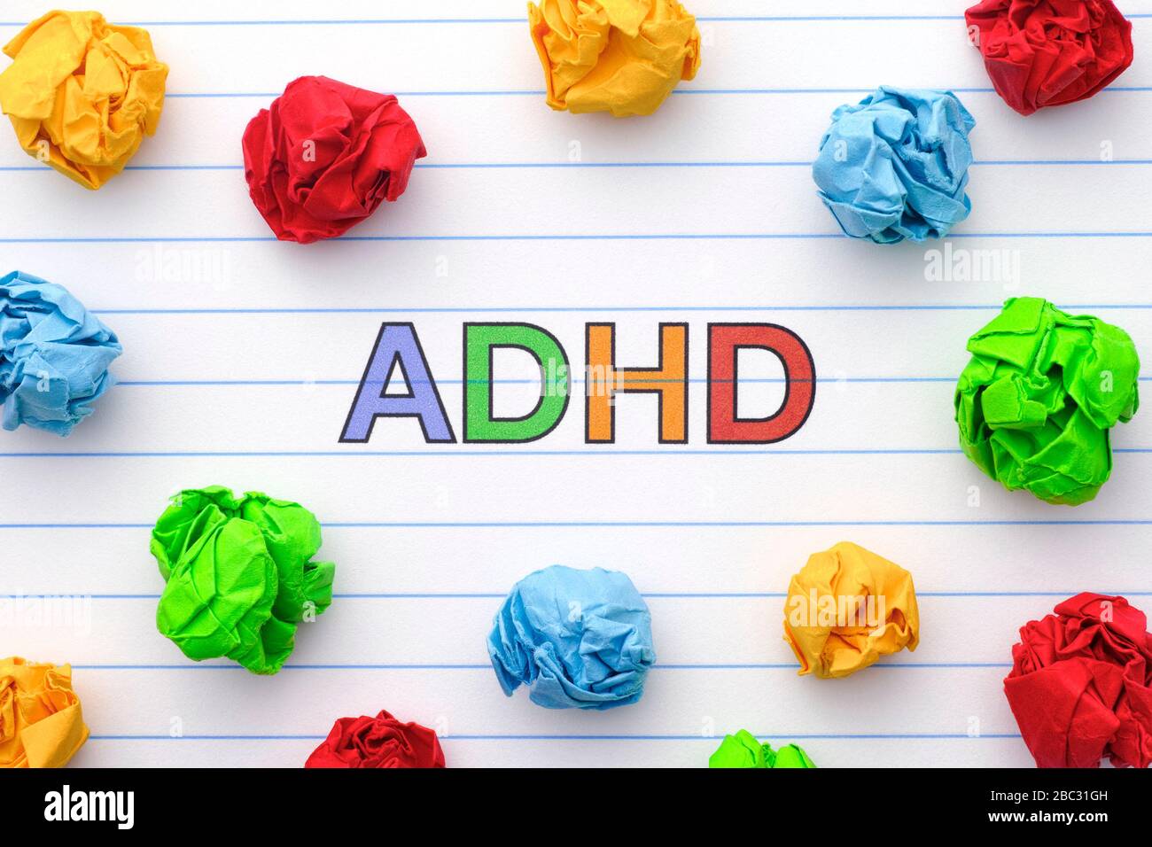 ADHD. Abbreviation ADHD on notebook sheet with some colorful crumpled ...