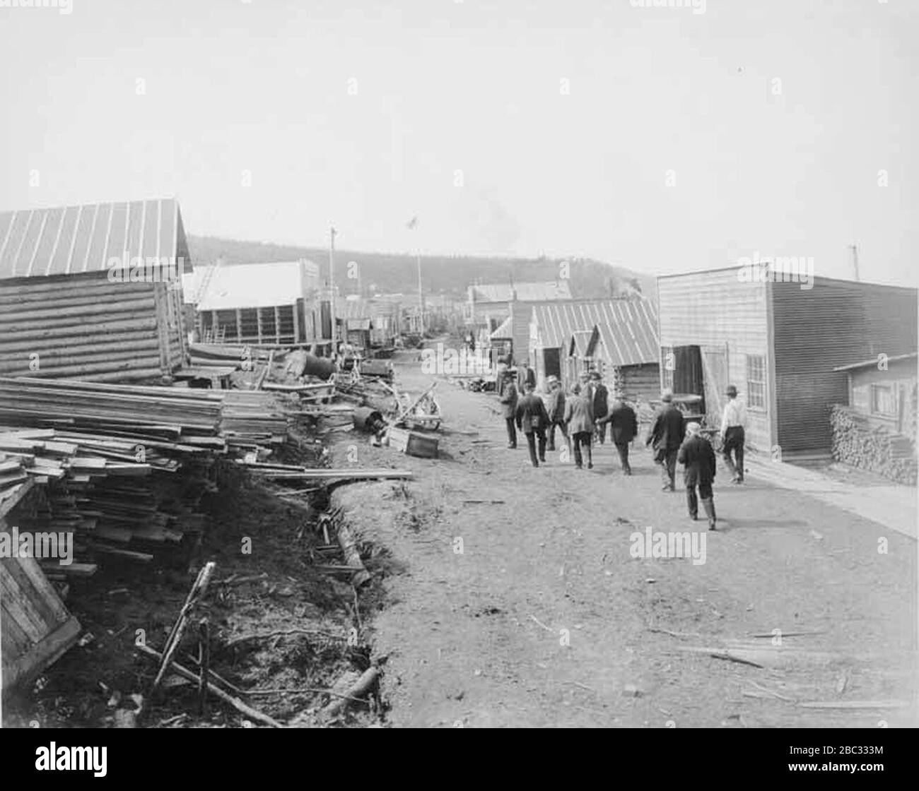 Group of men walking down street lined with a businesses, Ruby, ca 1914 ...