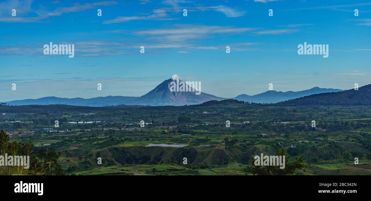 Sinabung volcano mountain very active and dangerous visible in distance ...