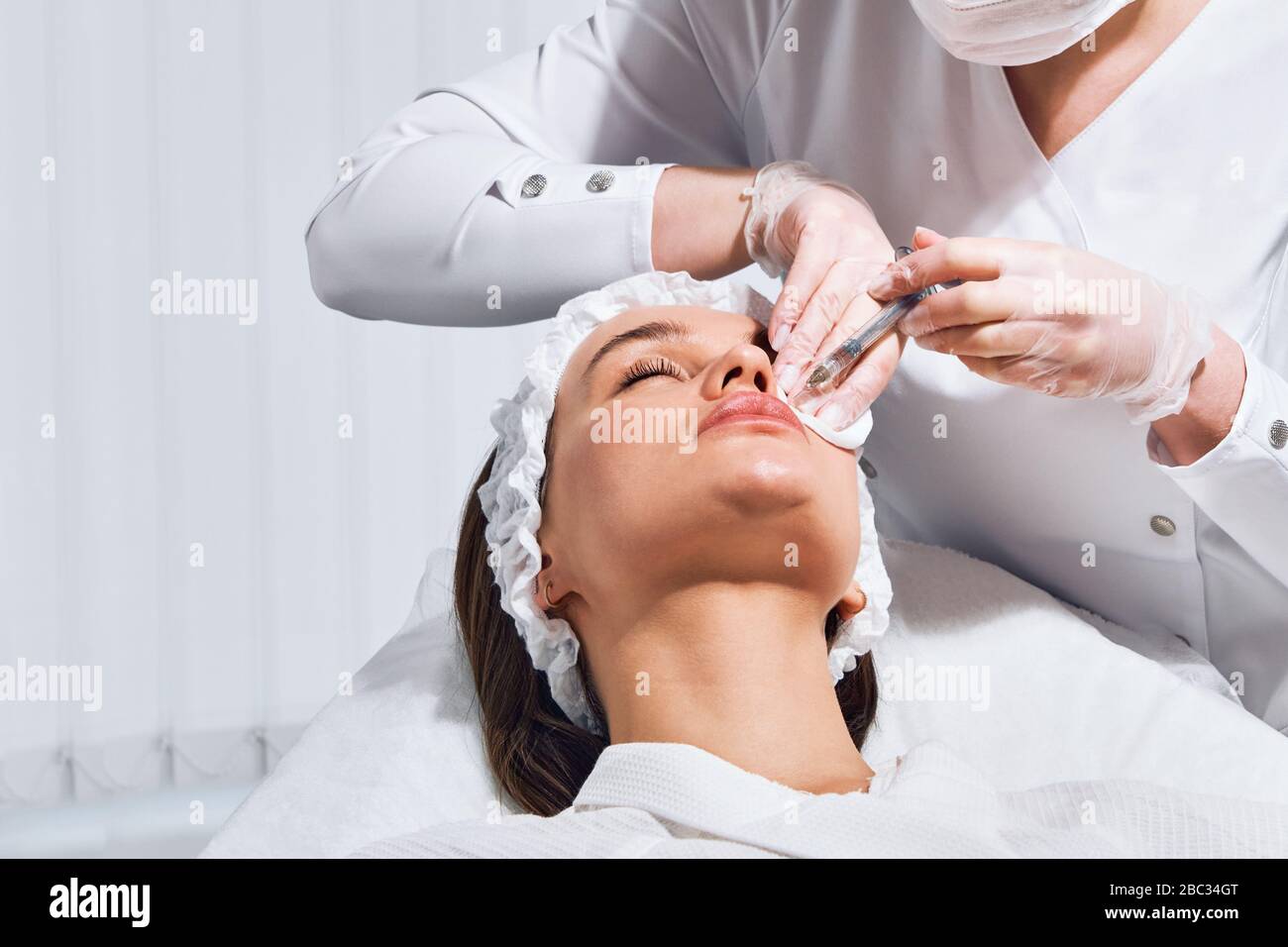 lip shape correction procedure in a cosmetology salon. The specialist ...