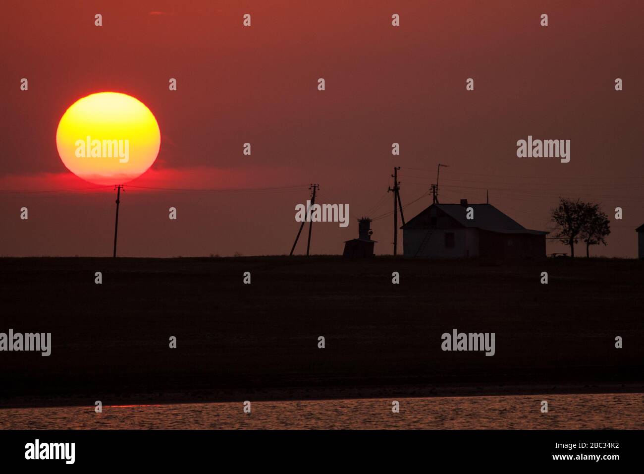 Rural land in the dusk light. Huge red sun setting down. Horizontal ...