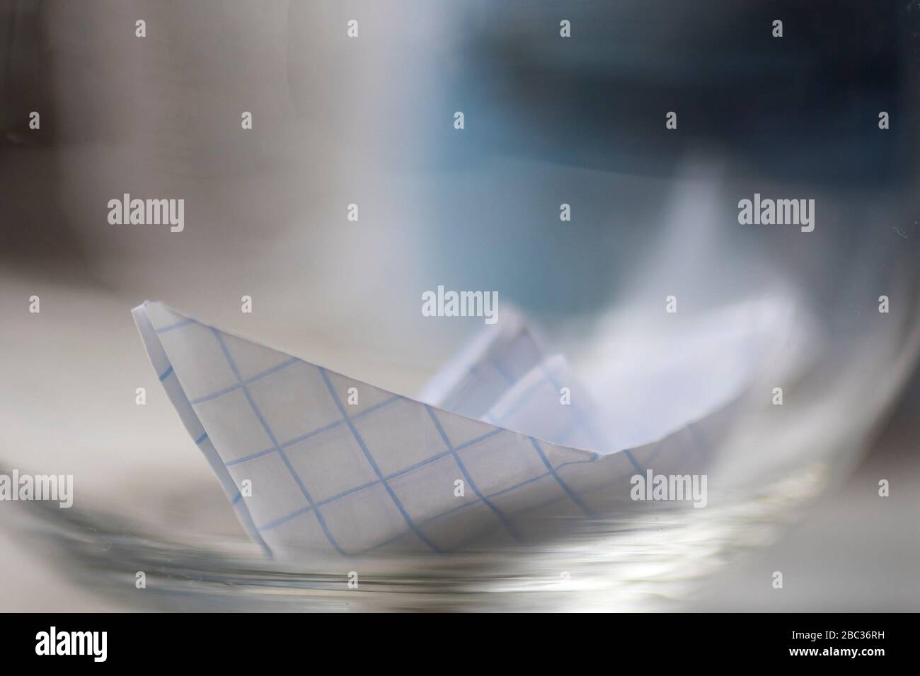 Paper checkered boat in a cup with water. Selective sharpness. Copy ...