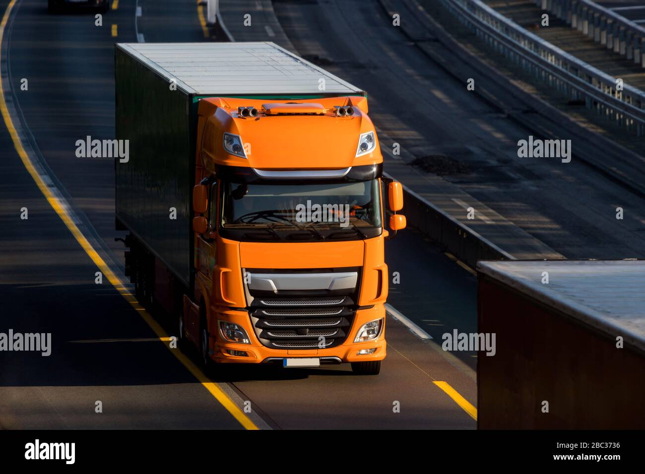 a modern orange truck driving on an highway Stock Photo - Alamy